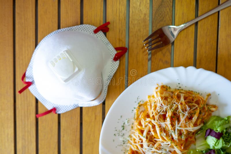 Top View of a Mask and a Plate of Food in a Restaurant. Stock Photo ...