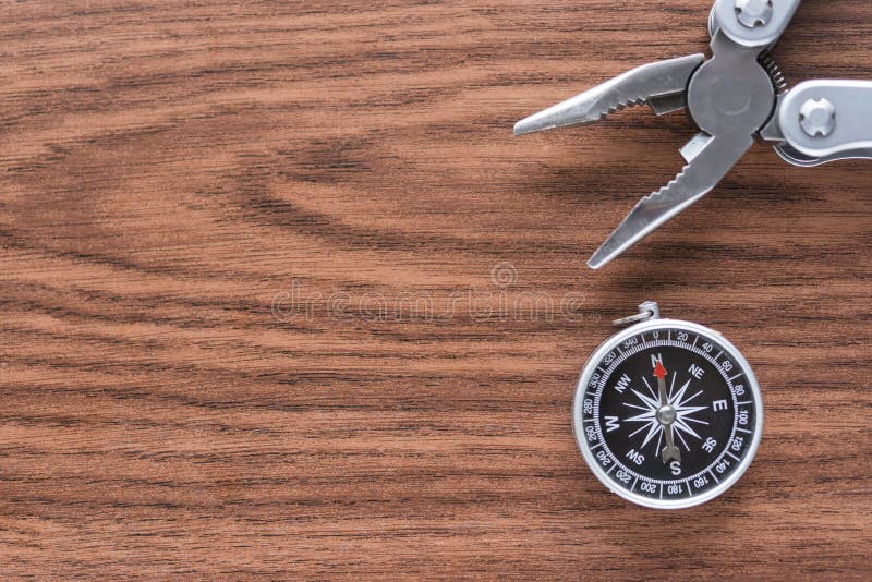 Top View of a Metal Compass with Multitool on a Wooden Table Stock ...