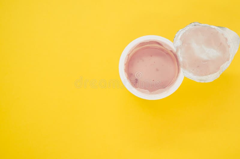 Top View of an Opened Plastic Container of Fruit Yogurt on a Yellow ...