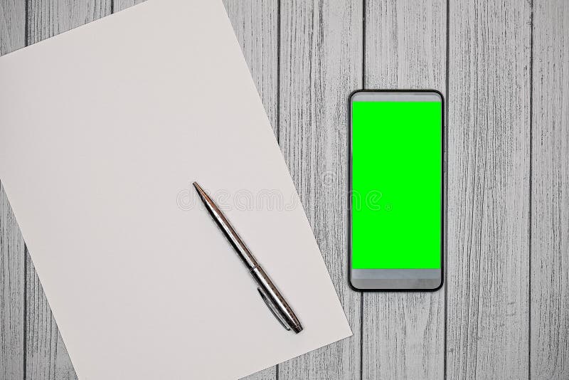 Top View of Phone with Green Screen Next To Pencil and Note Paper on ...