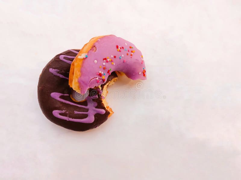 Pile of Bitten Chocolate Donut and Half of a Purple Donut Isolate on White Background. Sweet ...