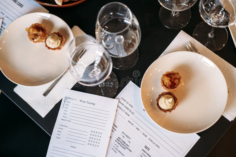 Top View of Plated Food Samples and Wine Tasting Card on a Black Table ...