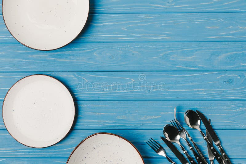 Top View of Plates with Utensil on Blue Table Stock Photo - Image of ...