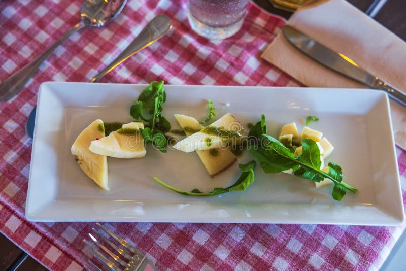 Top View of Rectangular Plate with Cheese Slices and Greens on Red and ...