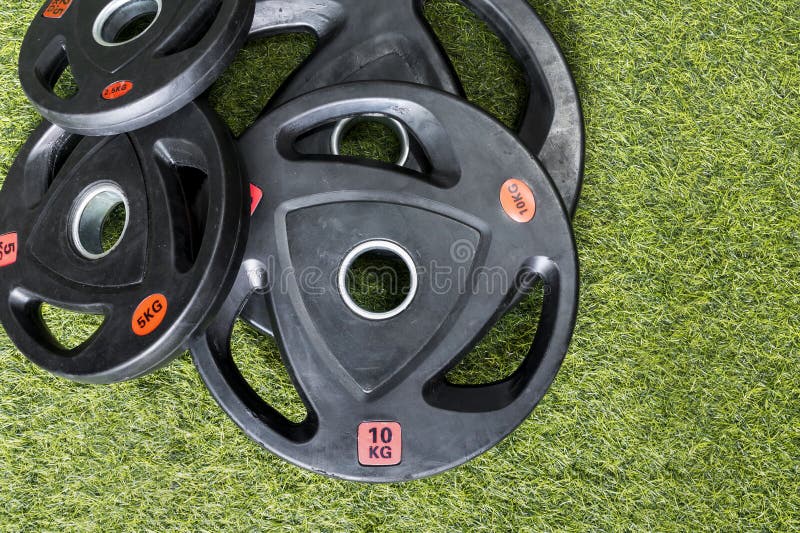 Top View of Rubberized Barbell Plates on the Artificial Grass Mat of a ...