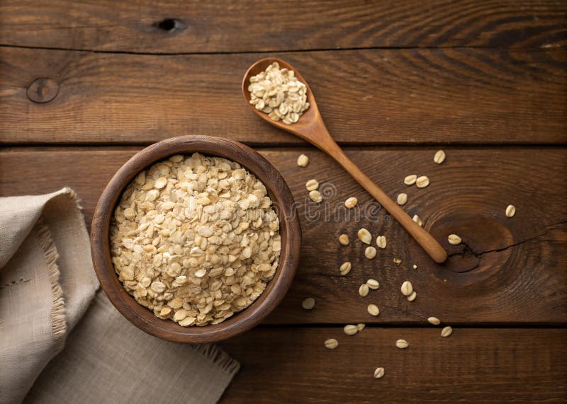 Top View of a Rustic Bowl Filled with Uncooked Oat Flakes on Wooden ...