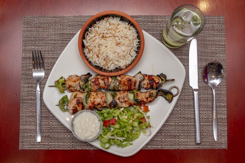 Top View of Shish Taouk, Rice, Sesame Paste, and Cutlery on a White ...