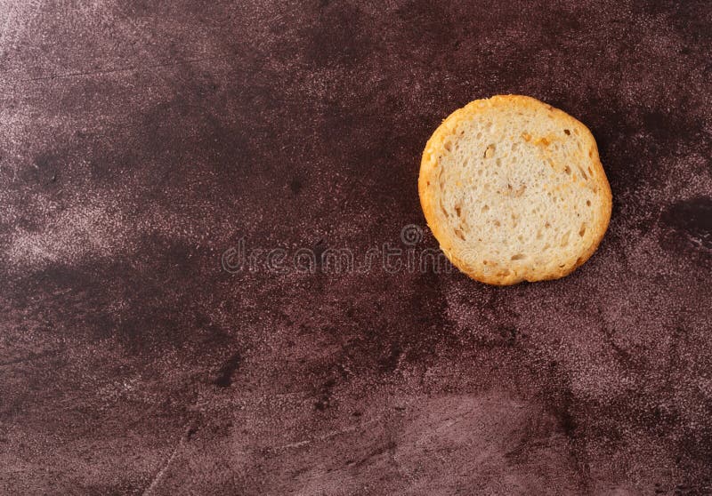 Top View of a Single Sesame Round Melba Toast Offset on a Maroon ...