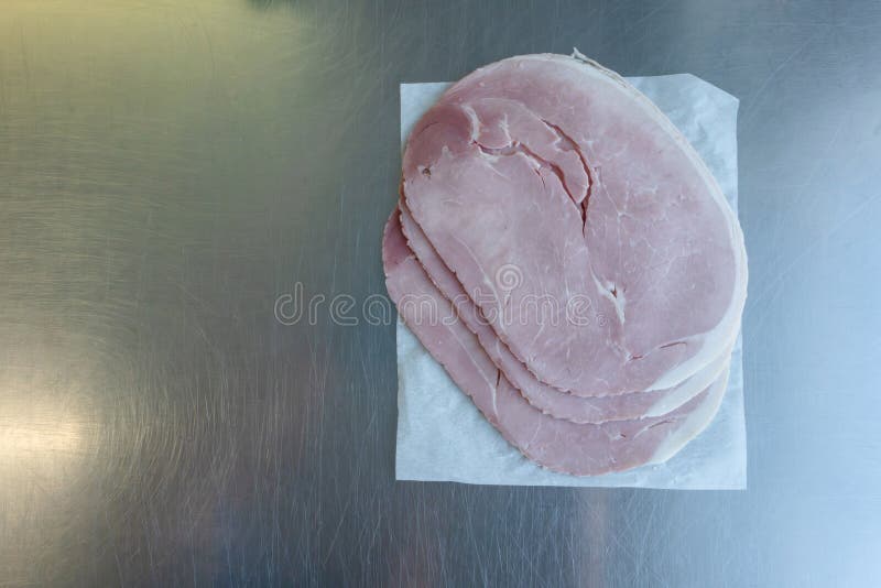 Top View Sliced Cooked Ham Separated with White Paper on a Metal Table ...