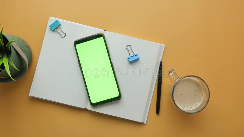 Top View of Smart Phone with Green Screen and Notepad on Table Stock ...