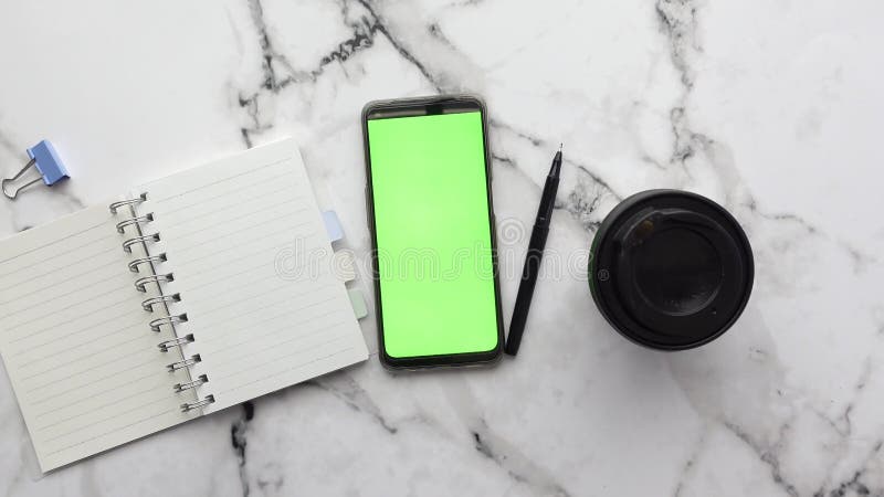 Top View of Smart Phone with Green Screen and Notepad on Table Stock ...