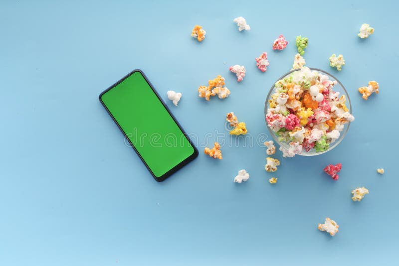 Top View of Smart Phone and Popcorn on Blue Background Stock Photo ...