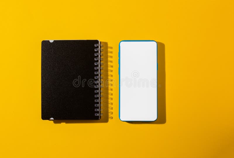 Top View of a Smartphone and a Notepad on a Yellow Background Stock ...