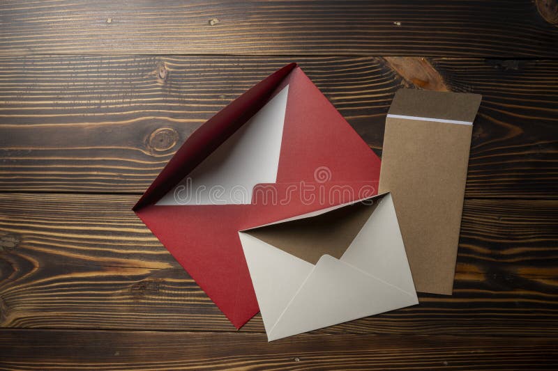 Top View of Stack of Three Envelope and Postcard on Wooden Background ...