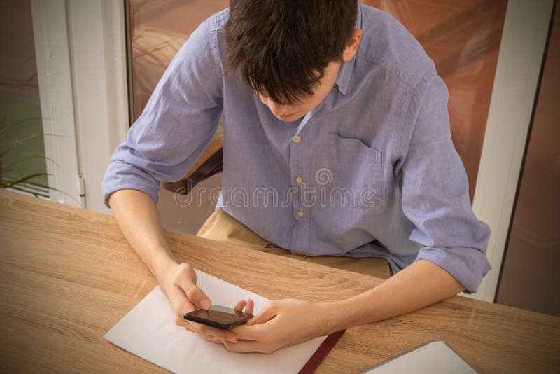 Student with Mobile Phone at Desk Stock Photo - Image of desk ...
