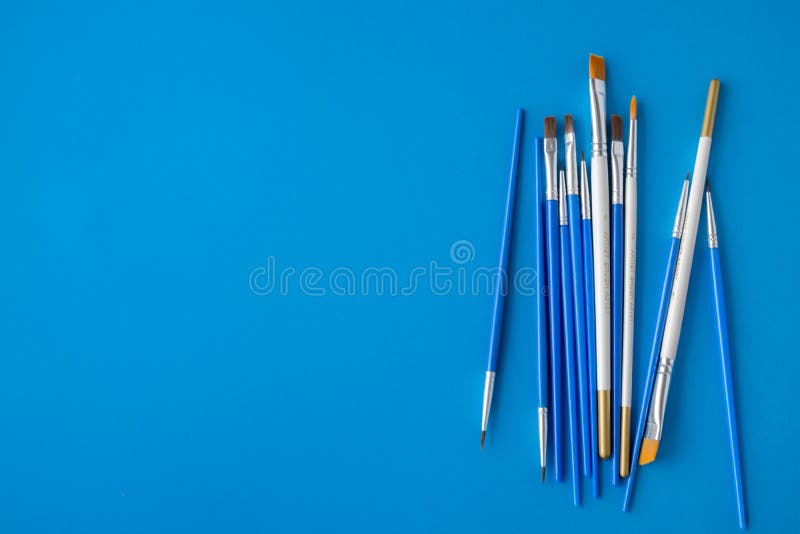 Top View Table Desk. Set of Different Artist Brushes on a Blue ...
