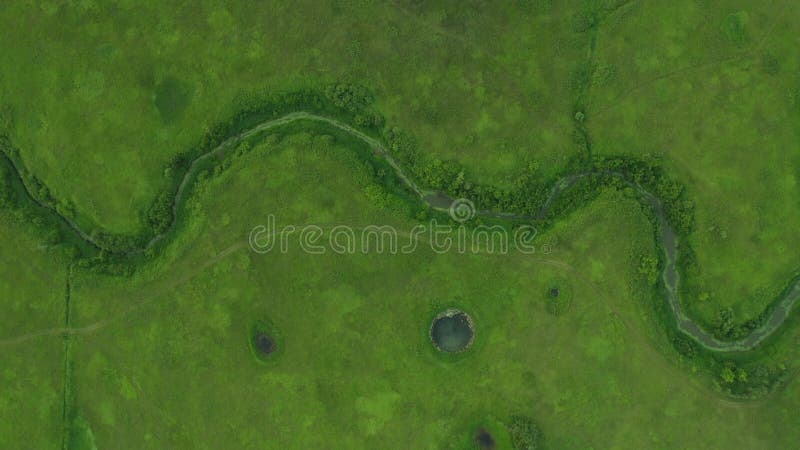 A Top View of the Thin River that Divides Large Green Grassy Fields ...