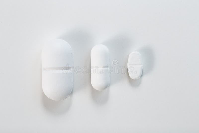 Top View Three Pills of Different Sizes on White Stock Photo - Image of ...