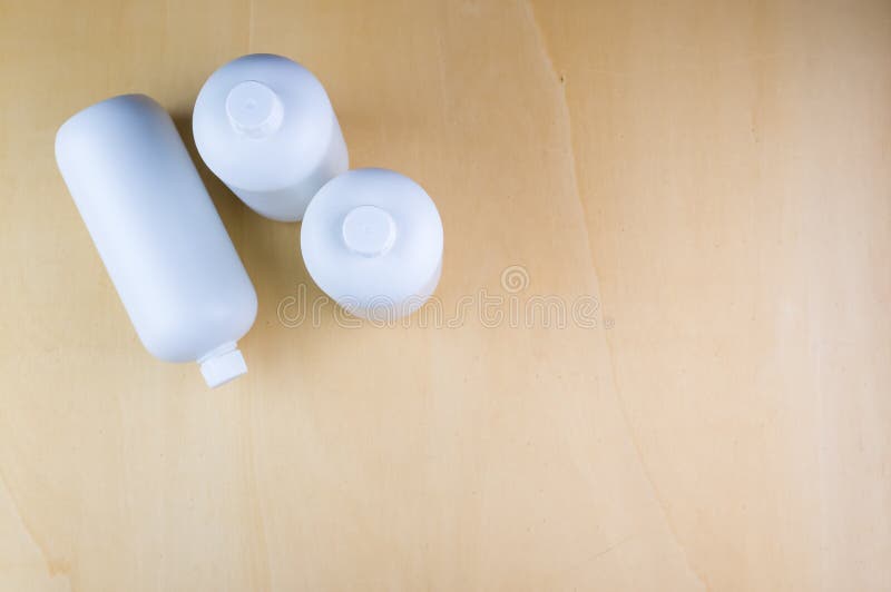 Top View of Three White Plastic Bottles on a Light Brown Surface Stock ...