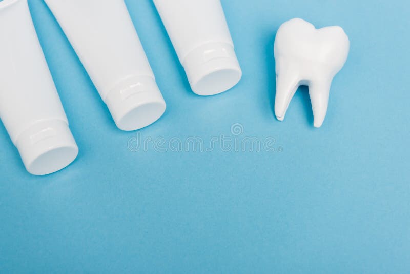 Top View of Tooth Model and Tubes with Toothpaste on Blue Background ...