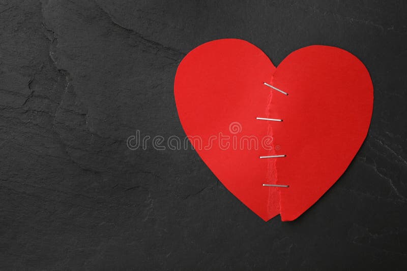Top View of Torn Paper Heart with Staples on Black Stone Background ...