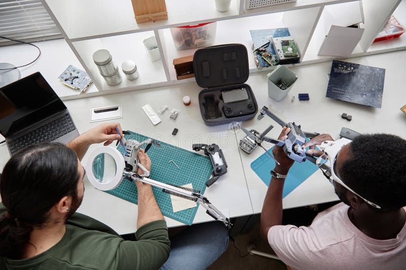 Two People Fixing Drones at Table in Tech Repair Shop Stock Image ...