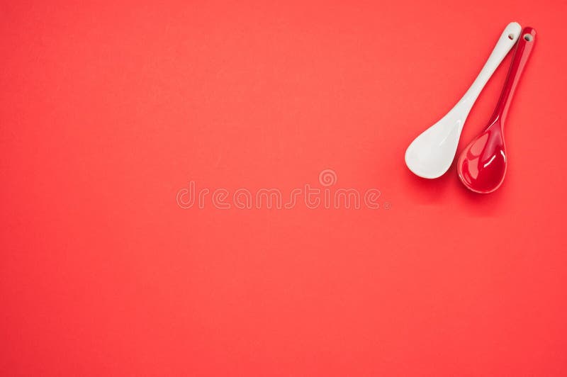 Top View of Two Small Ceramic Spoons, One Red and One White, Placed on ...