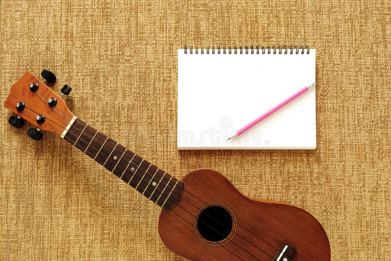 Top View of Ukulele with Notebook and Pencil Placed on Brown Fab Stock ...