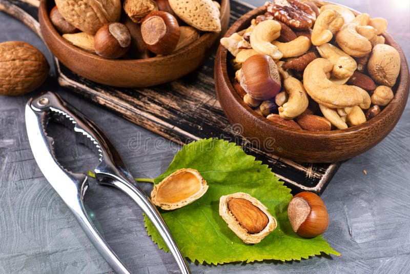 Top View of Various Nuts in Wooden Bowls and Nutcracker on Gray Surface ...