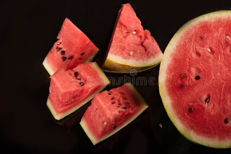 Top View of Watermelon Slices and Halved Watermelon on Black Surface ...