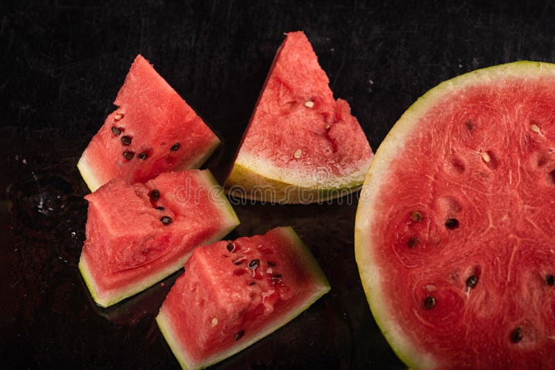 Top View of Watermelon Slices and Halved Watermelon on Black Surface ...
