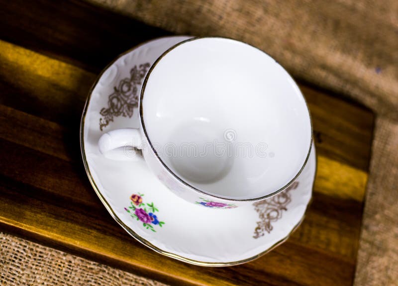 A Top View of a White Decorated Cup with a Plate on a Wooden Board ...