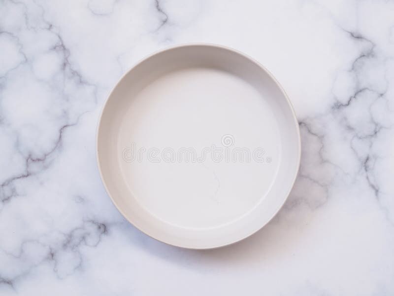 White Glazed Ceramic Round Dish for Food Isolated on Marble Table Stock ...