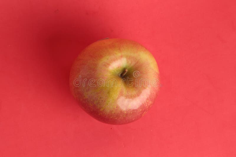 Top View of a Whole Apple Under the Lights on a Red Surface Stock Photo ...