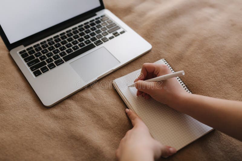 Top View of Woman on the Bed Using Laptop and Writing Down in Notebook ...
