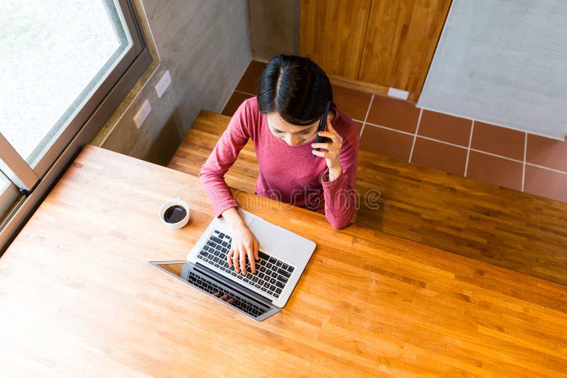 Top View of Woman Talk To Cellphone when Using the Laptop Computer ...