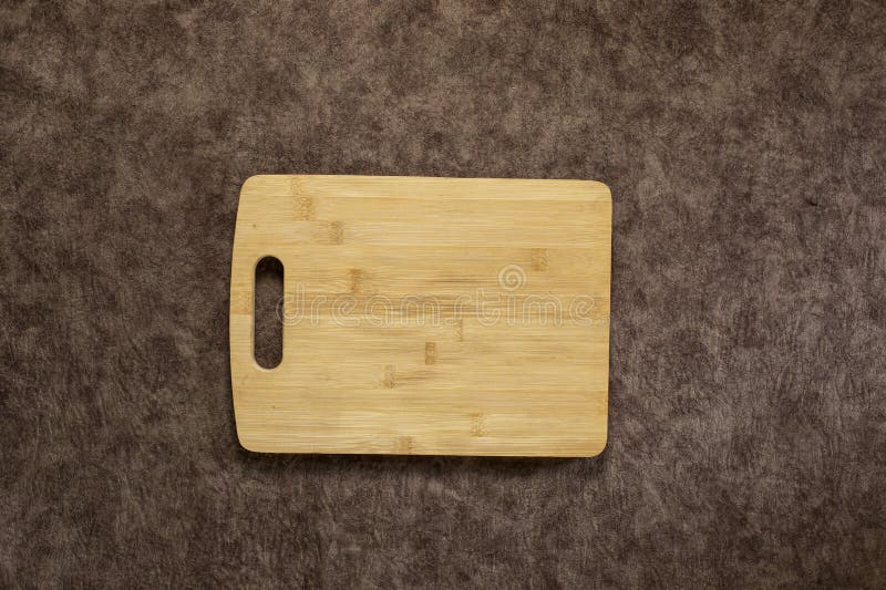 Top View of Wooden Cutting Board on Brown Textured Background Stock ...