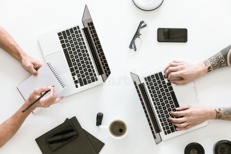 Top View of Workspace with Two Laptops and Male Hands Typing and ... Top View of Workspace with Two Laptops and Male Hands Typing and ...