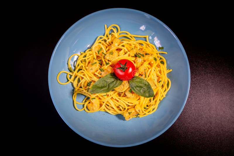 Top View of Yellow Spaghetti with Prawns, a Cherry Tomato and Basil ...