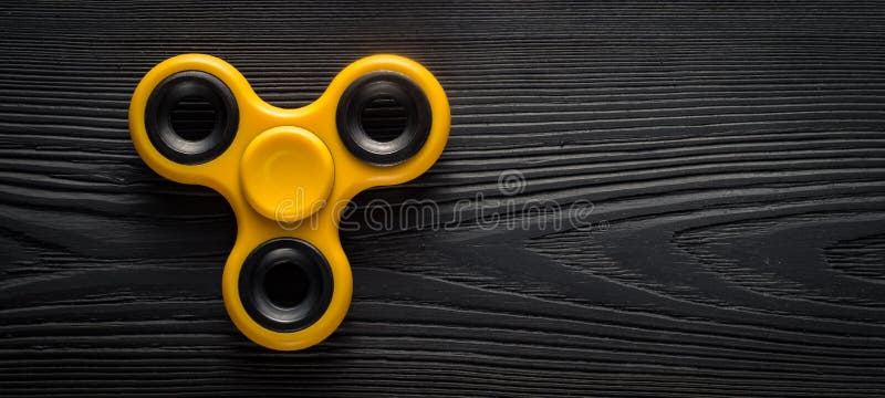 Top Wiew Yellow Spinner on a Black Background Stock Photo - Image of ...