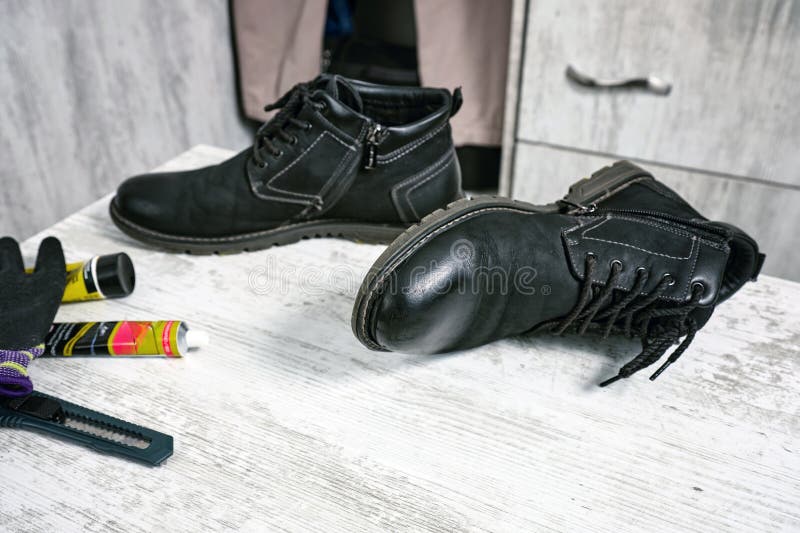 A Torn Old Boots, Against the Background of a Table with Tools ...