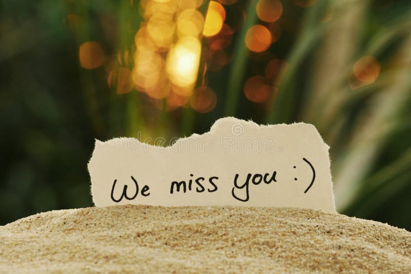 A Torn Piece of Paper with the Words we MISS YOU Written in the Sand ...