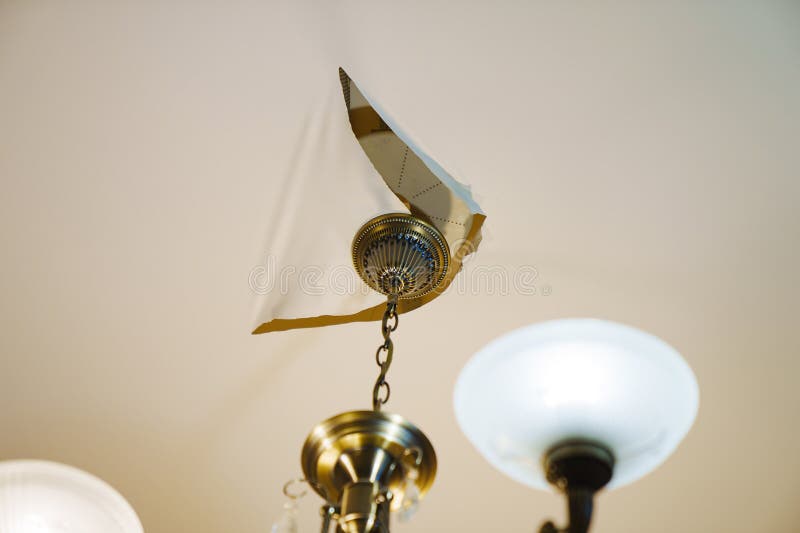 A Torn Stretch Ceiling with a Ceiling Lamp Stock Image - Image of ...