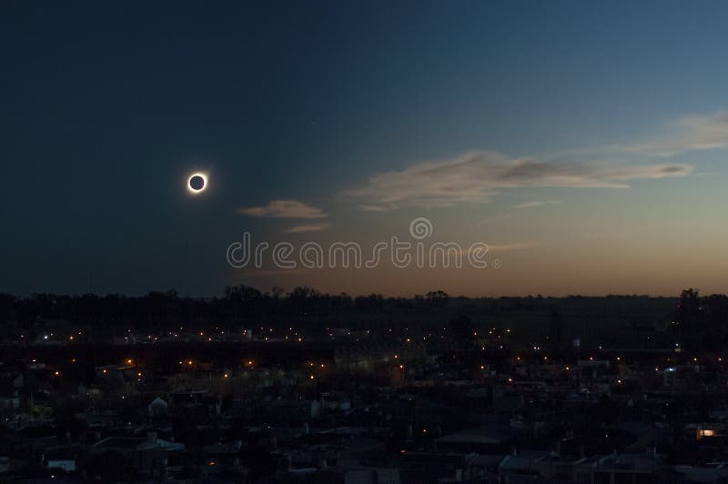 Total Solar Eclipse during the Evening Above a Modern Town Surrounded ...