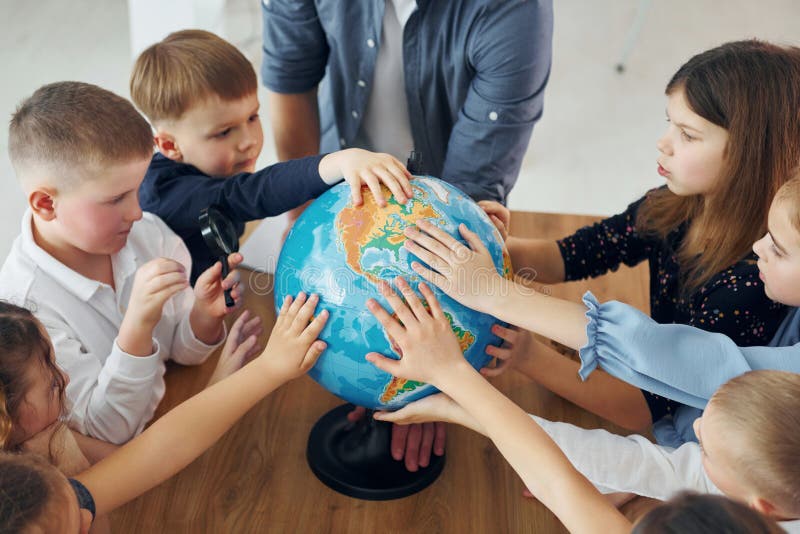 Touching the Earth Globe. Group of Children Students in Class at School ...