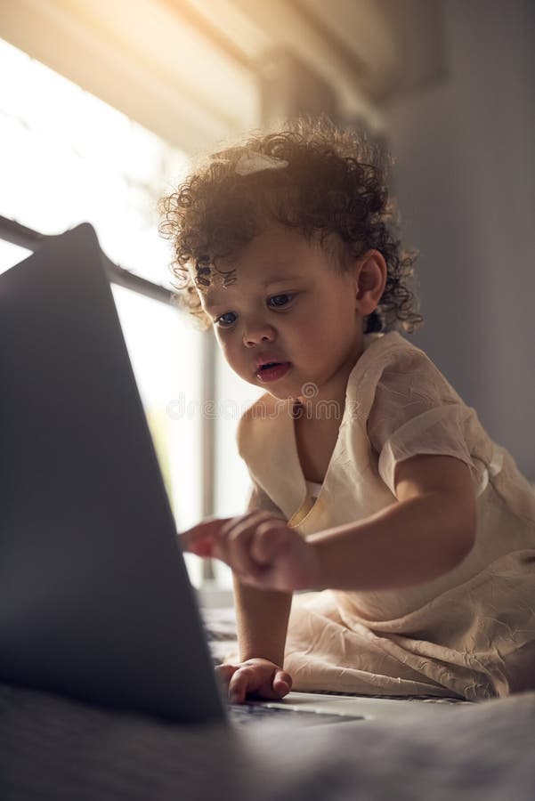 Touching the Future. an Adorable Little Girl Using a Laptop while ...