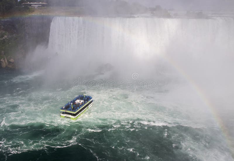 Tour Boat Navigating through Mist Near Niagara Falls with a Rainbow in ...