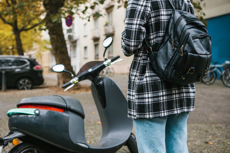A Tourist with a Backpack is Going To Use an Electric Scooter through a ...
