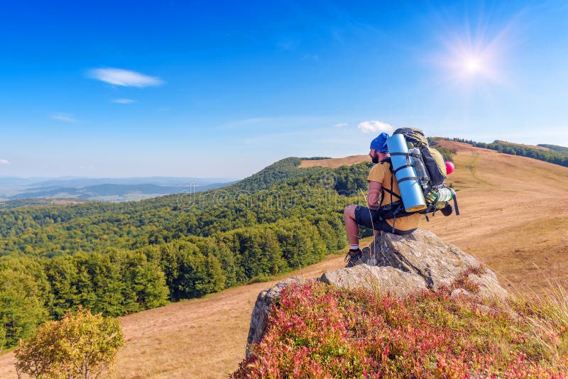A Tourist with a Backpack Sits on a Rock Stock Image - Image of nature ...