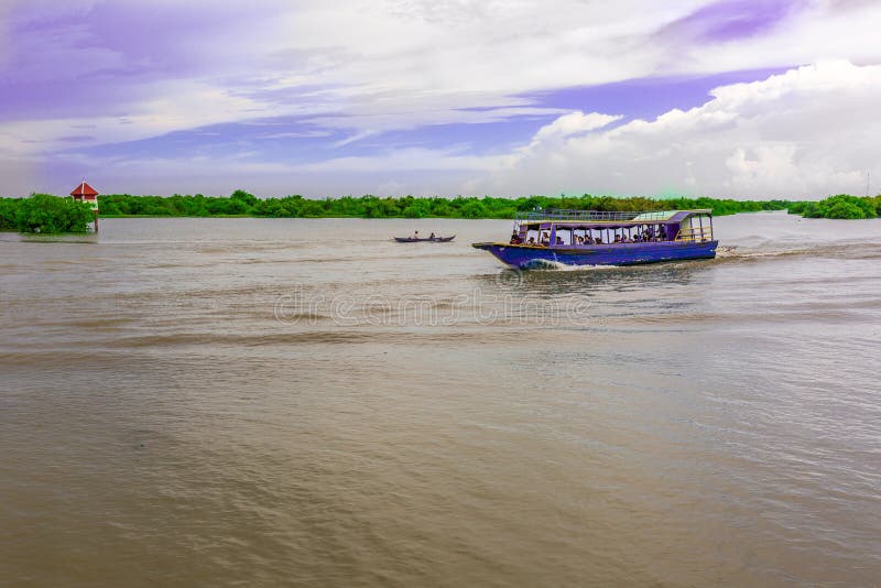 A Tourist Boat and a Small River Boat Sailing in a River Under a ...